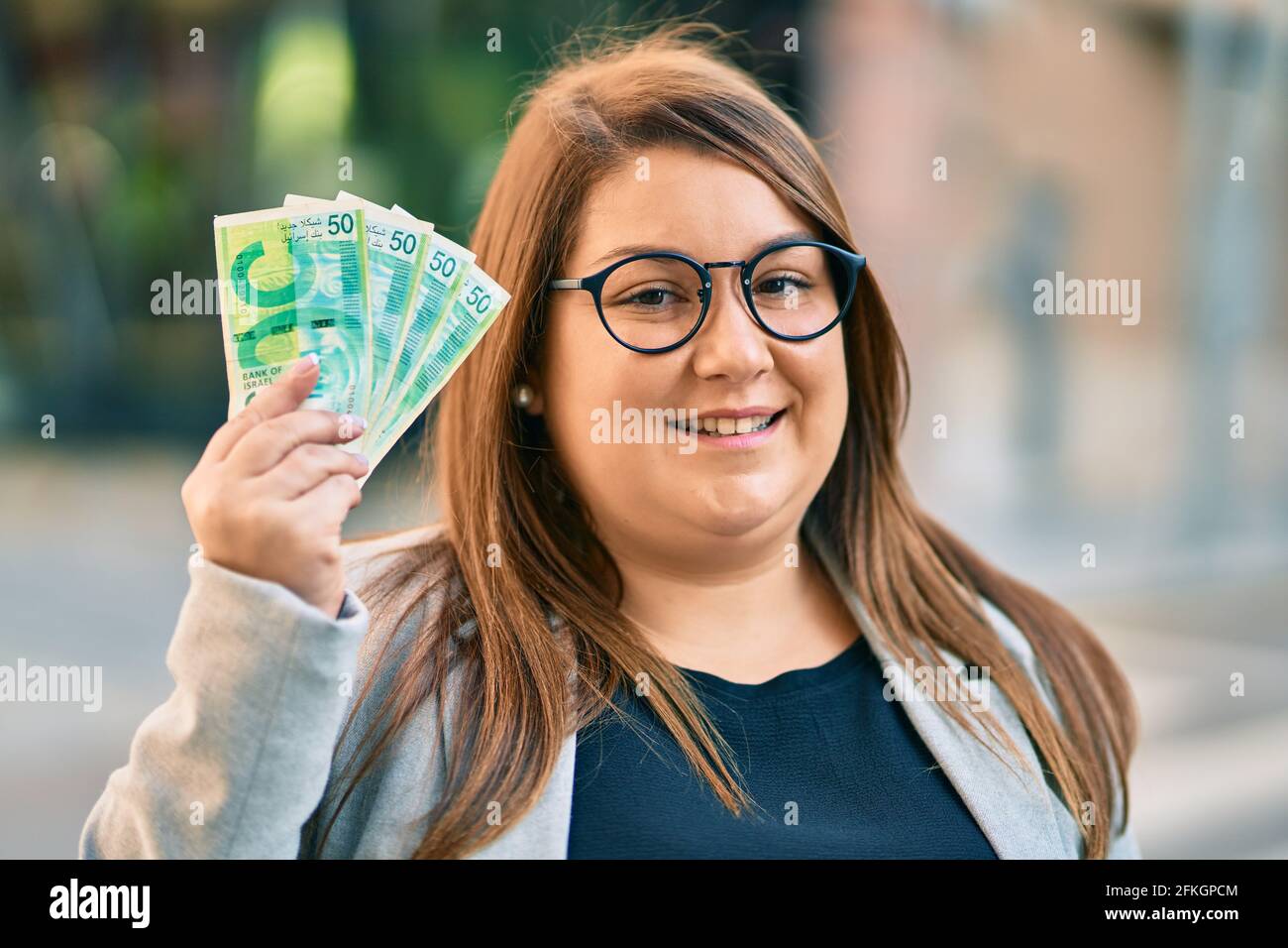 Young hispanic plus size businesswoman smiling happy holding israel ...