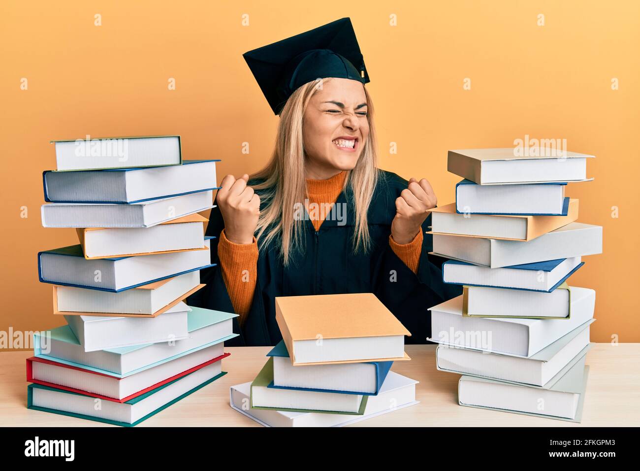 Young caucasian woman wearing graduation ceremony robe sitting on the ...