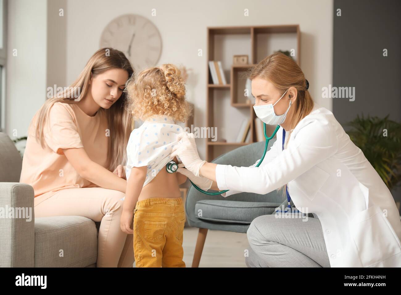 Pediatrician examining little girl at home Stock Photo - Alamy