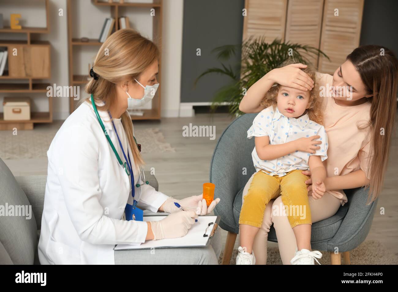Pediatrician examining little girl at home Stock Photo - Alamy