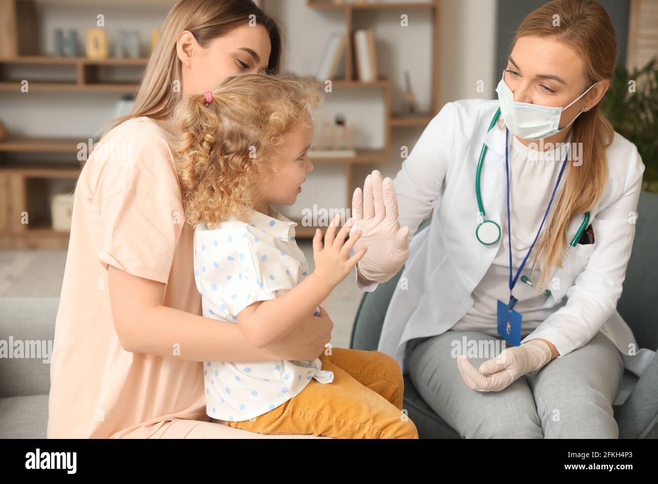 Pediatrician examining little girl at home Stock Photo - Alamy