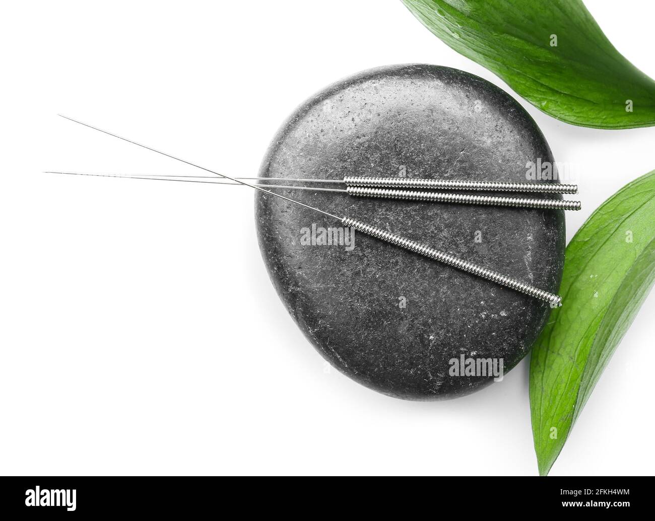 Acupuncture needles and spa stone on white background Stock Photo - Alamy