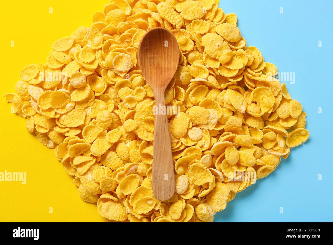 Spoon and tasty cornflakes on color background Stock Photo - Alamy