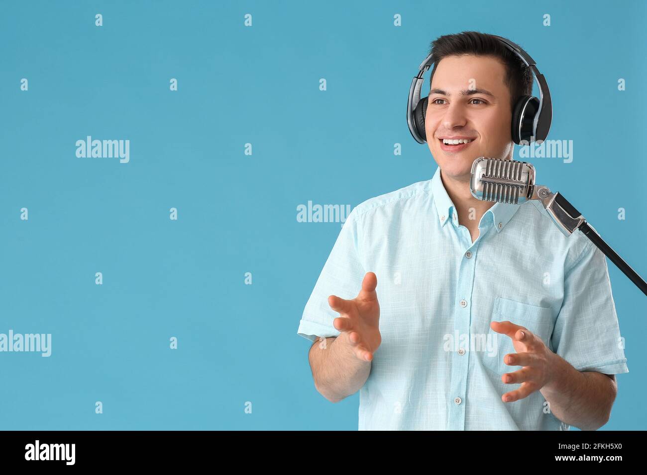 Male radio presenter with microphone on color background Stock Photo ...