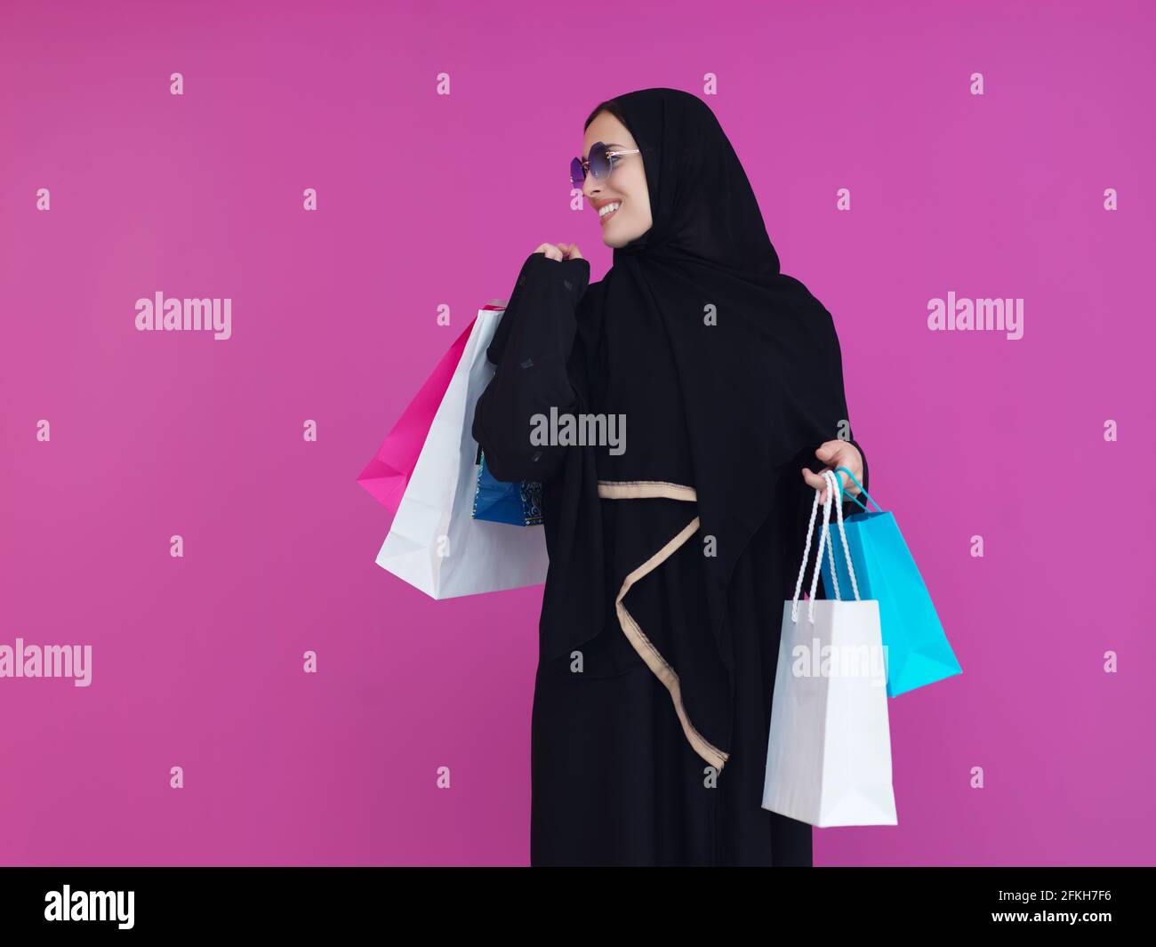 Happy Muslim woman posing with shopping bags. Arabic woman wearing ...