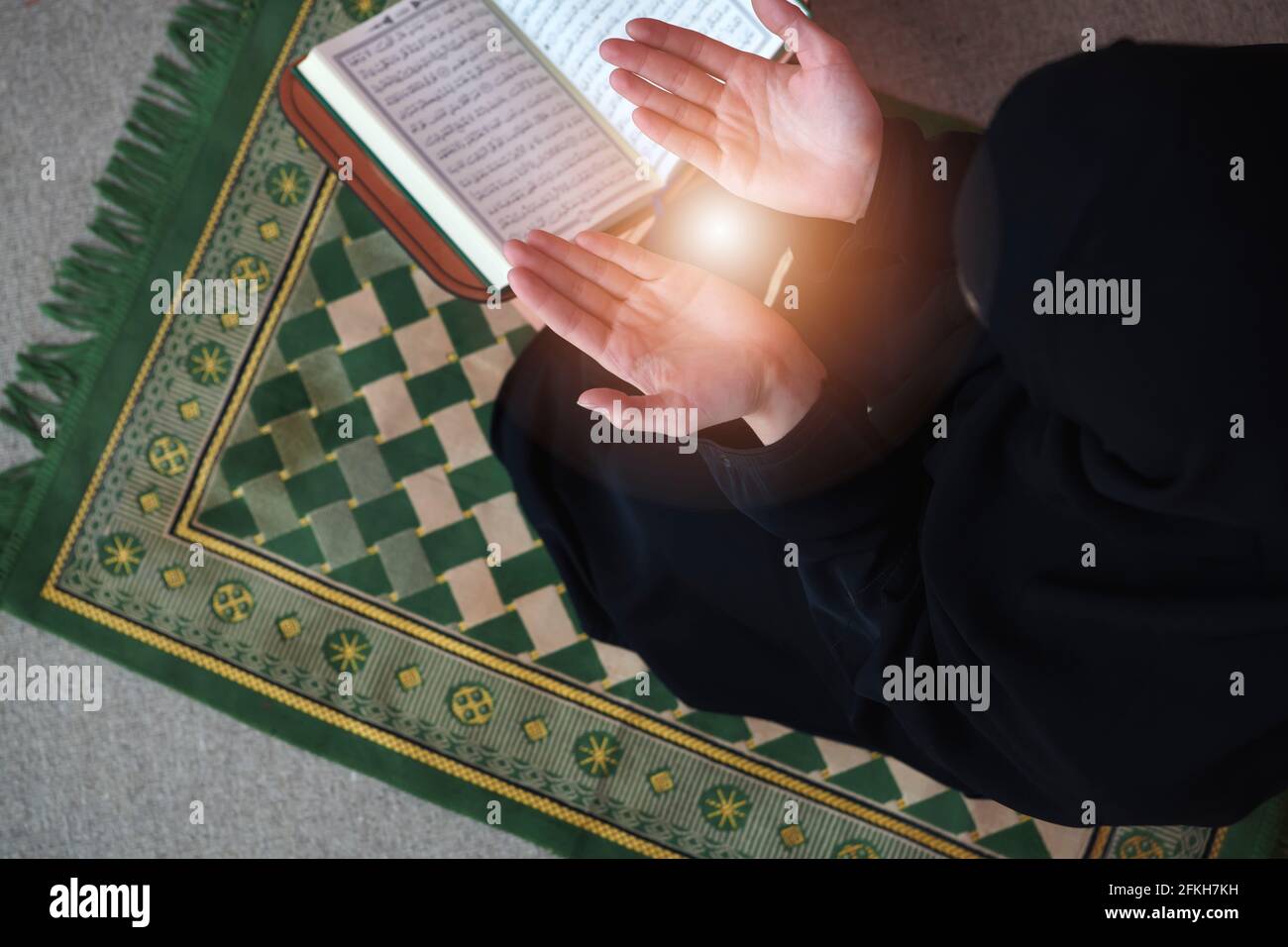 Middle eastern woman praying and reading the holy Quran Stock Photo - Alamy