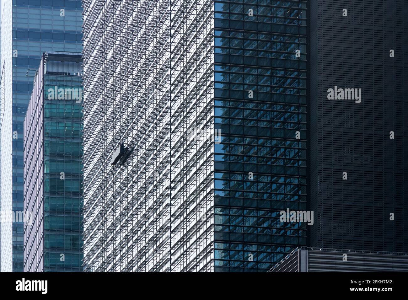 Window cleaners in a gondola (Building Maintenance unit BMU) on ...