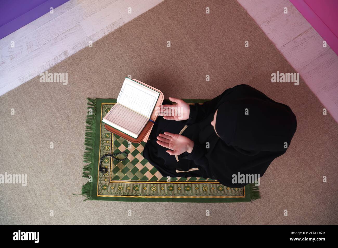Middle eastern woman praying and reading the holy Quran Stock Photo - Alamy