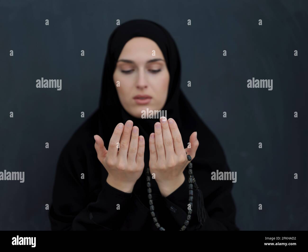 Portrait of young Muslim woman making dua. Arabian girl wearing abaya ...