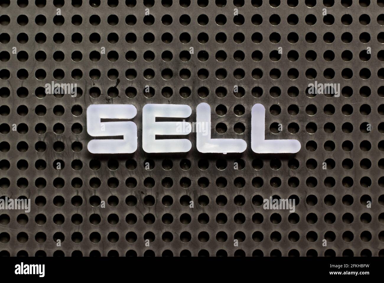 White color letter in word sell on black pegboard background Stock ...
