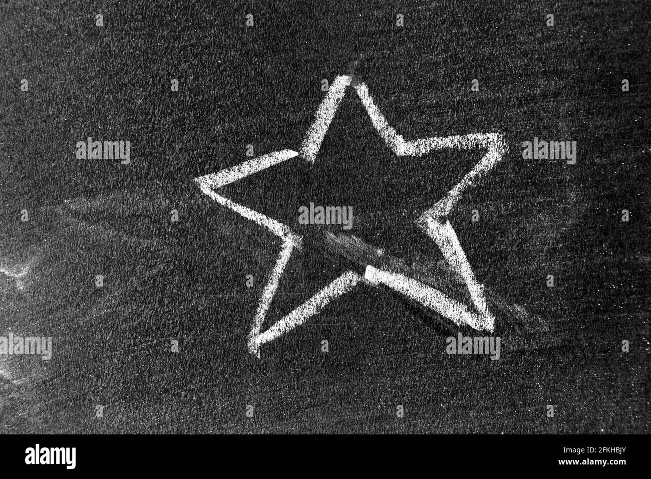 White color chalk hand drawing as star shape on blackboard or ...