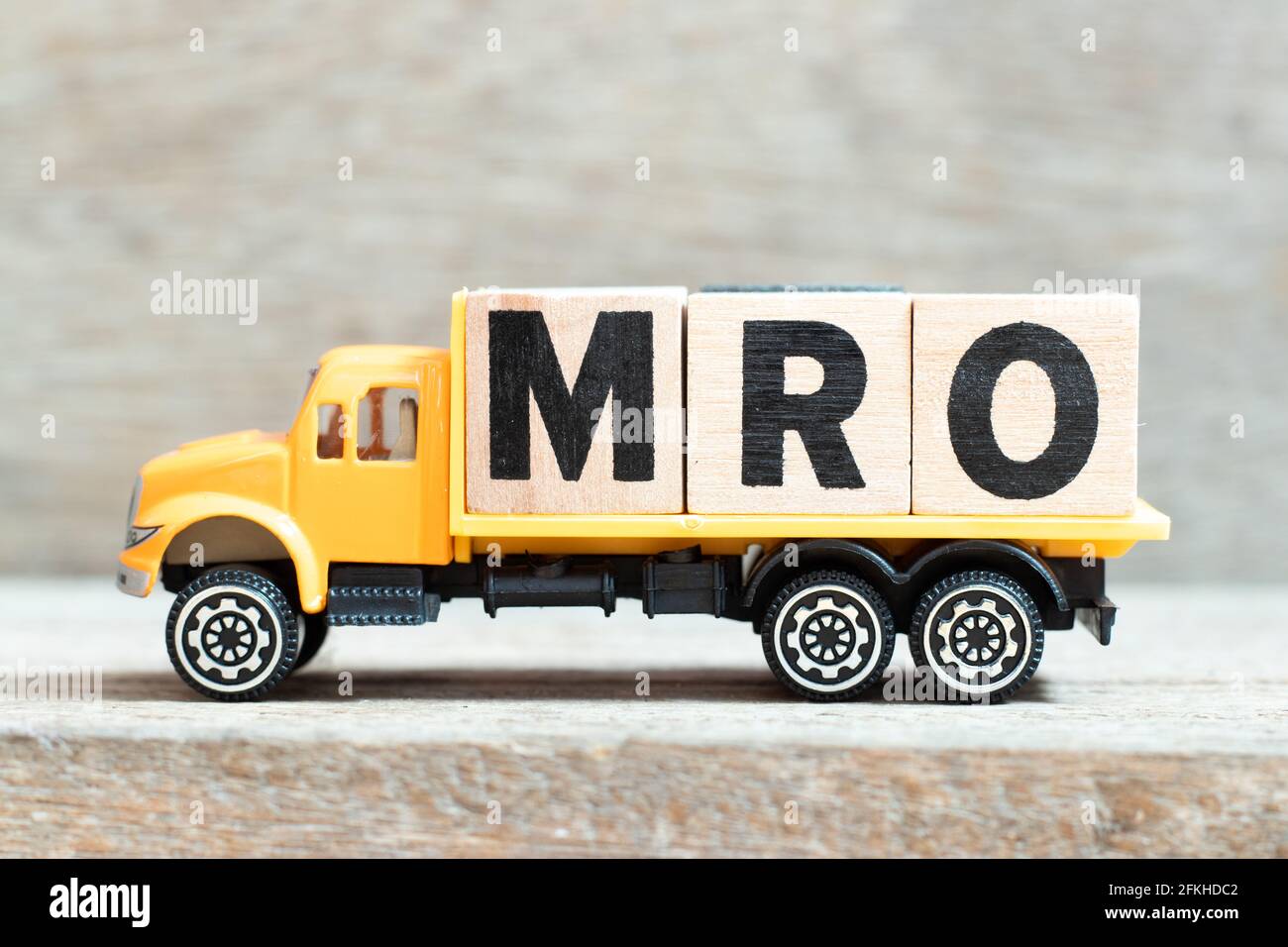 Toy truck hold alphabet letter block in word MRO (Abbreviation of ...