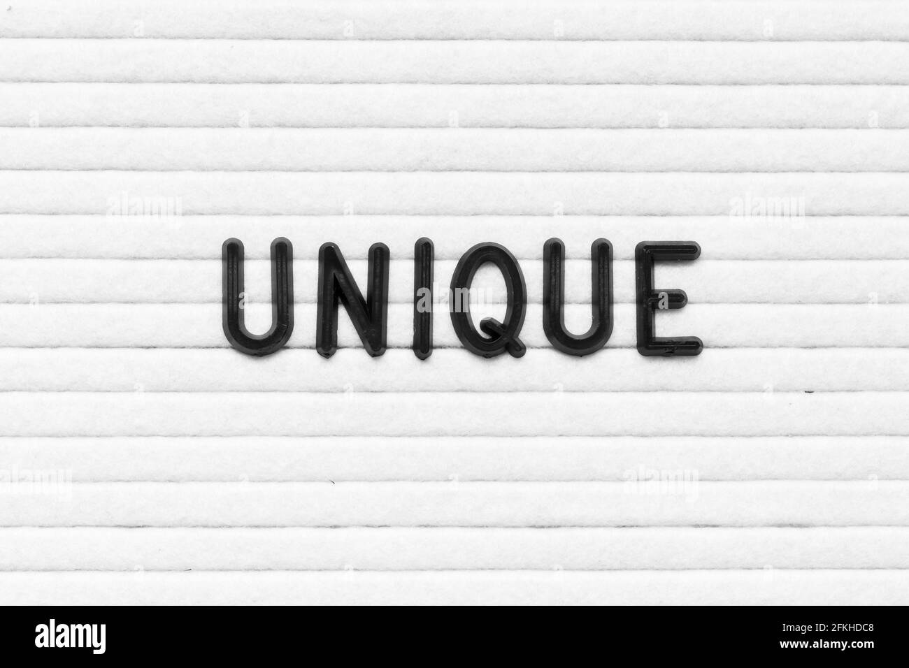 Black color letter in word unique on white felt board background Stock ...