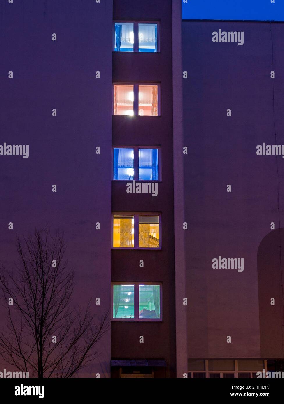 Different colors of lights in the windows of the building in the early ...