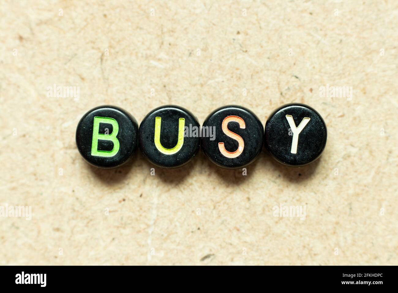 Black color round alphabet letter block in word busy on wood background ...