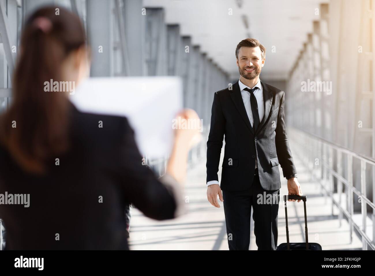 Female representative meeting business partner in airport Stock Photo ...