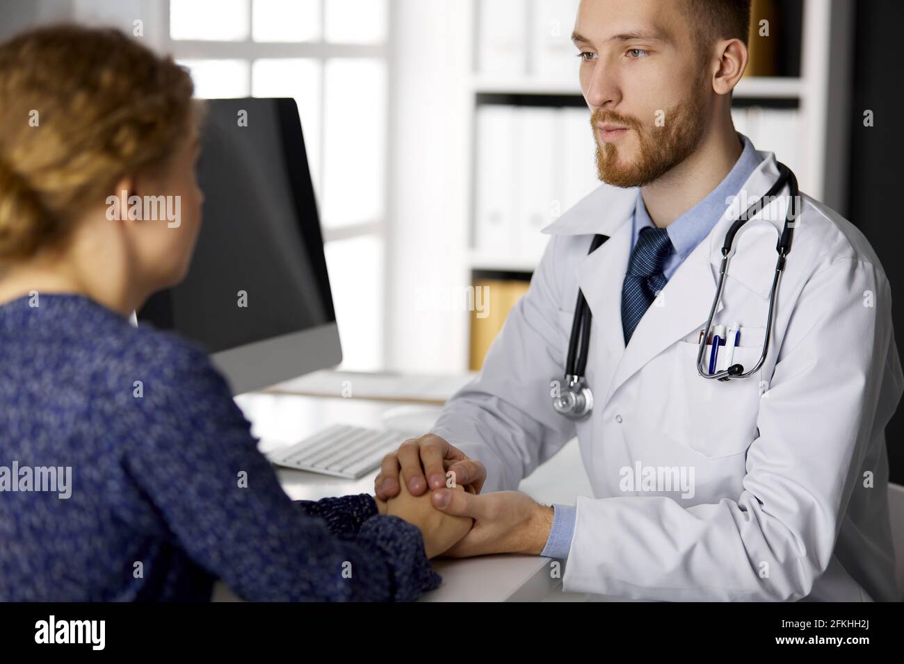 Friendly doctor reassuring his female patient. Medical ethics and trust ...