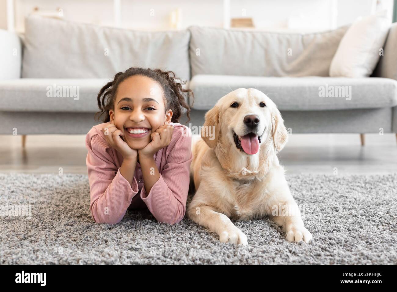 Young afro girl having fun with dog at home Stock Photo - Alamy