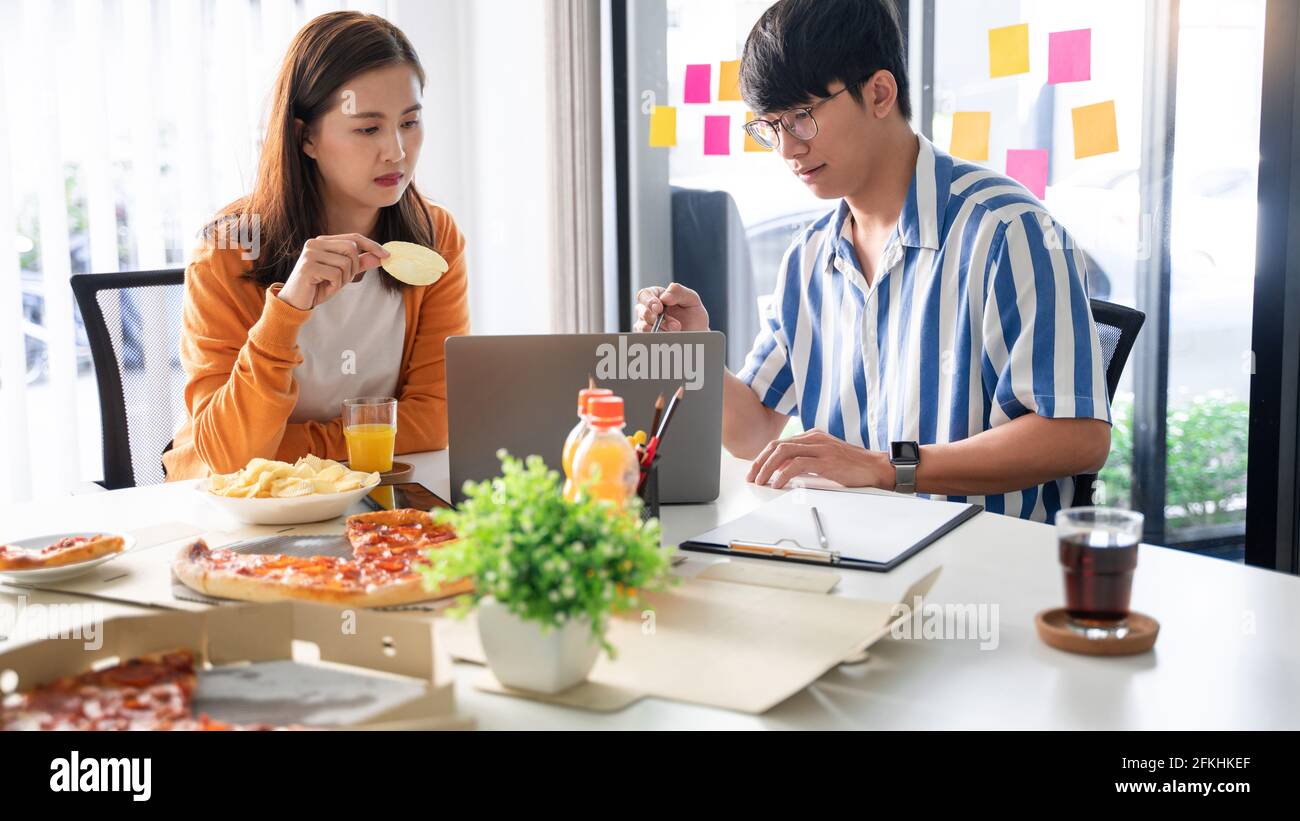 Happy business team workers talking about project and sharing meal ...