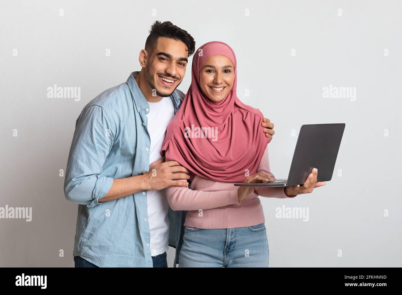 Portrait Of Happy Islamic Couple Posing With Laptop Computer In Hands ...
