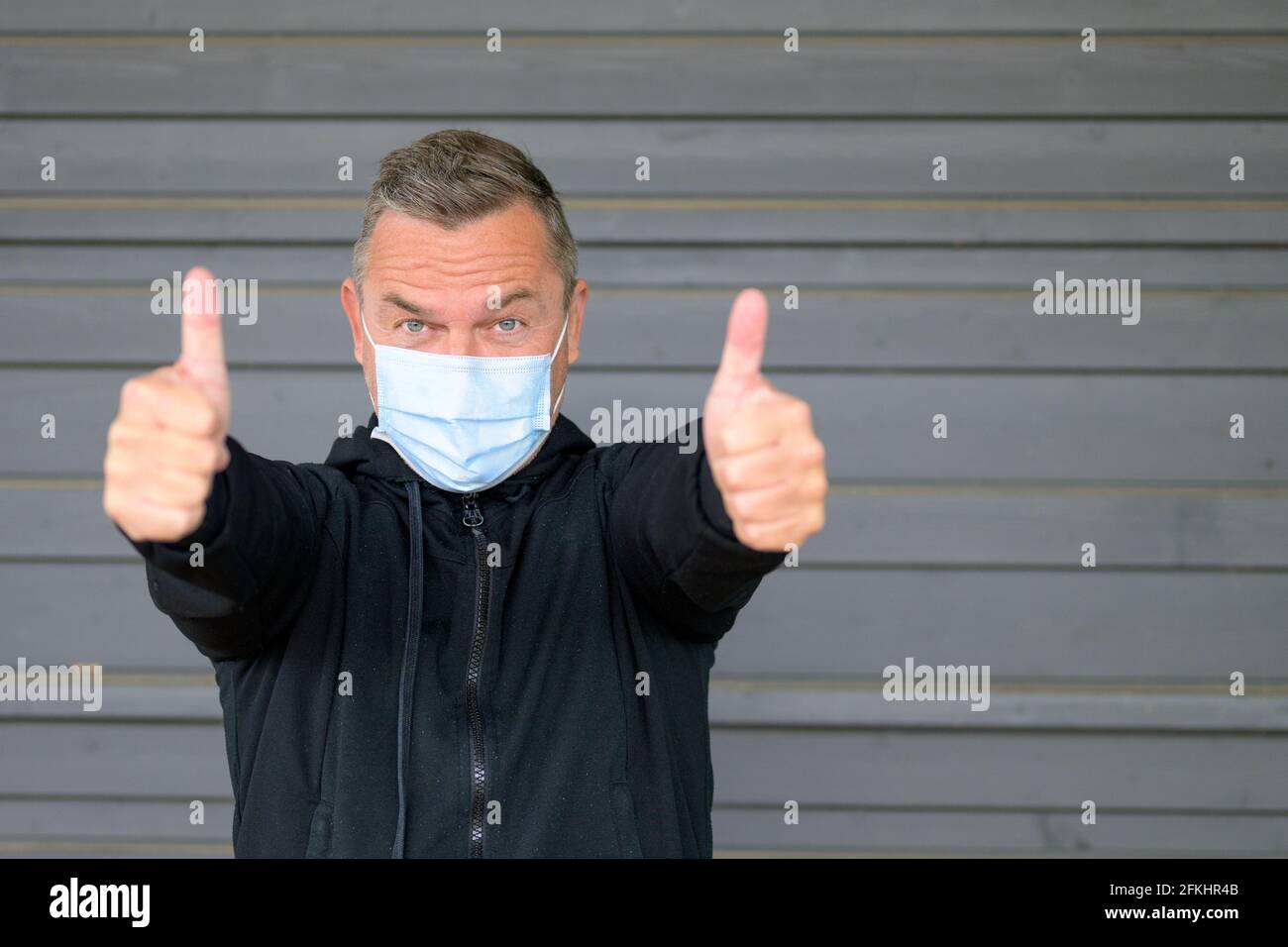 Portrait of a confident middle-aged man wearing protection mask while ...