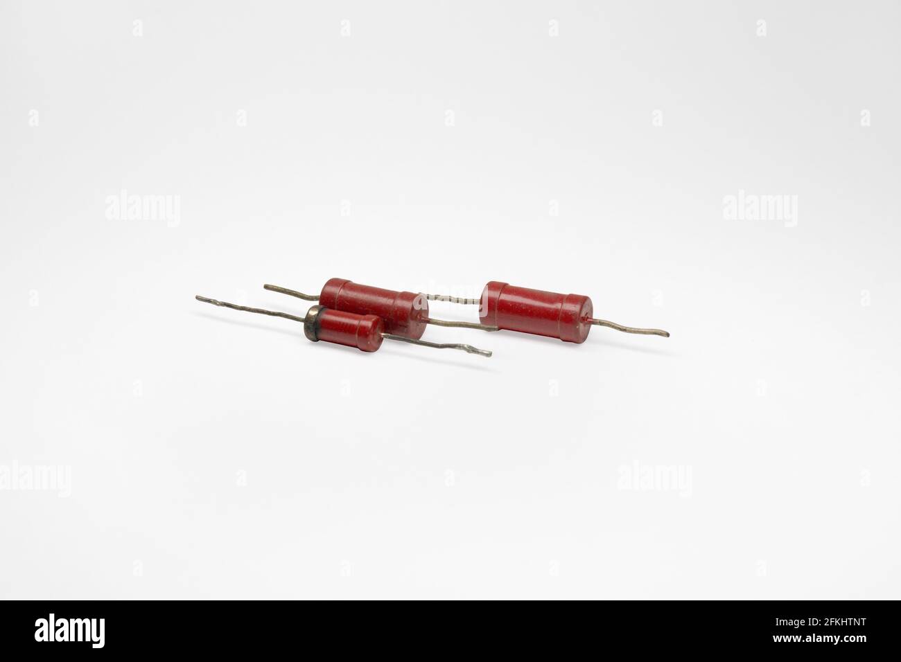 resistor set: three red cylindrical electronic components with leads ...