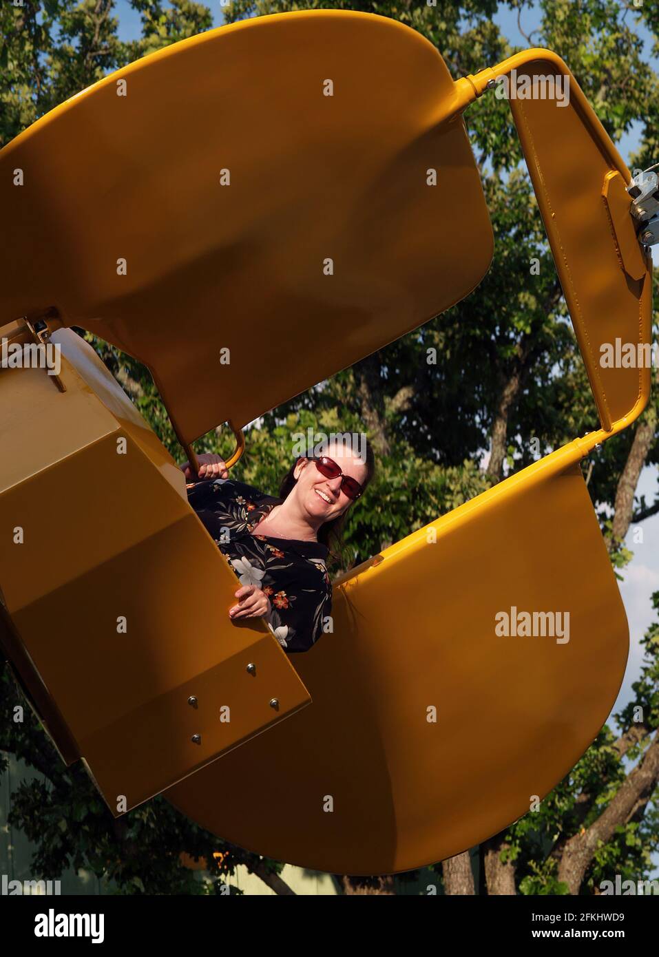 A young woman smiles with delight as she flies high in the air on a ...