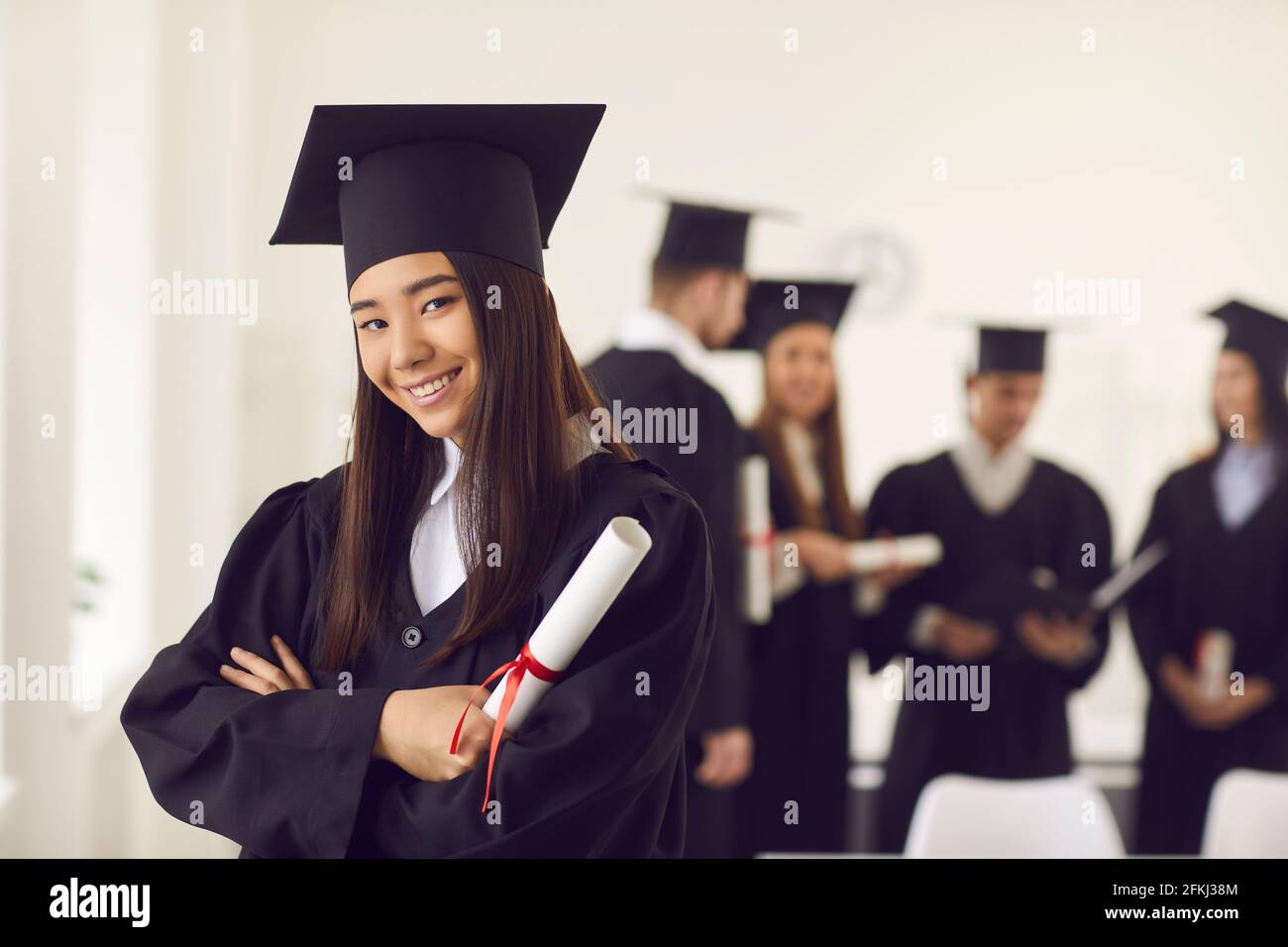 Happy asian girl student university graduate standing and looking at ...