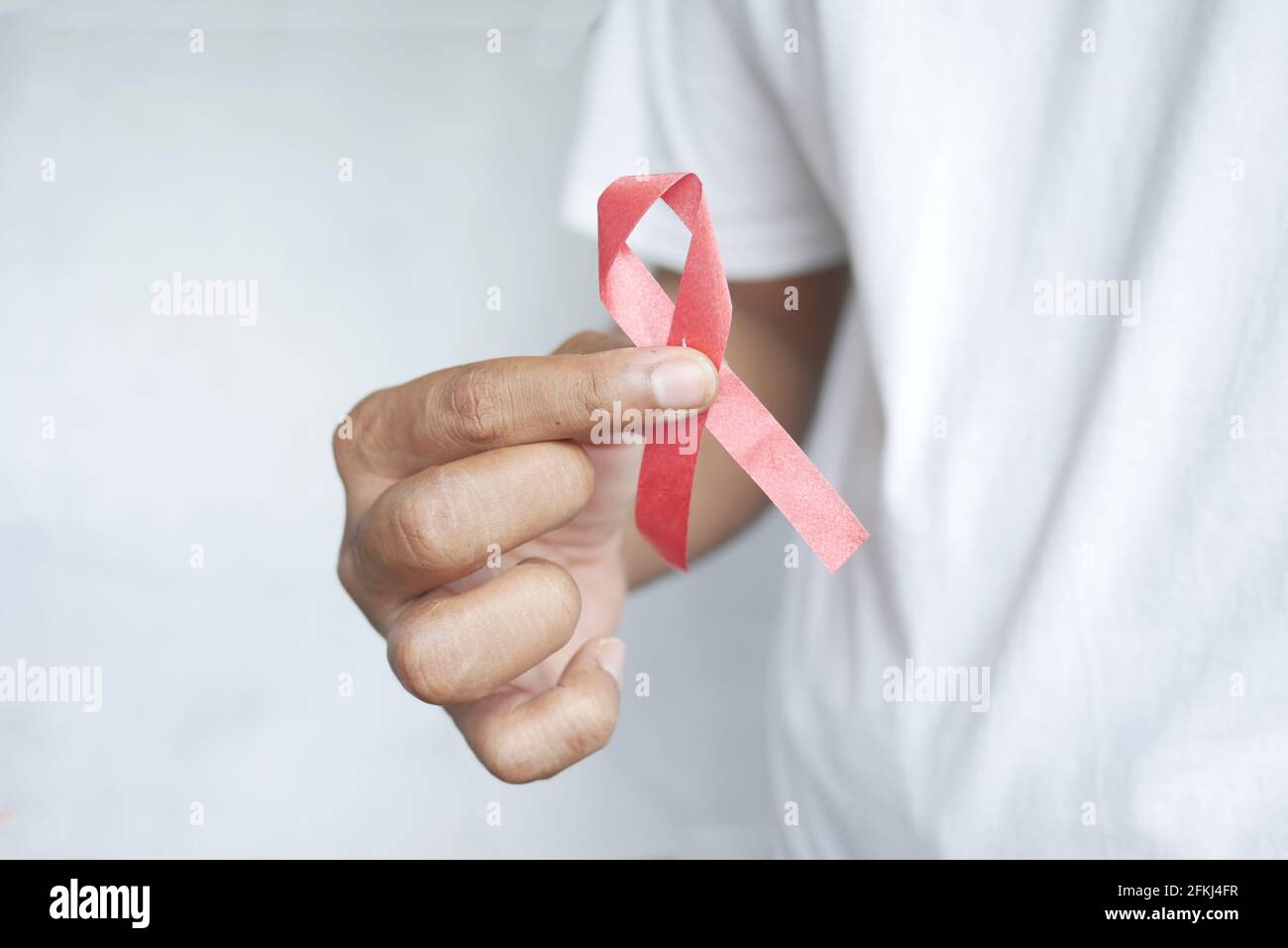hand holding red HIV ribbon with copy space Stock Photo - Alamy