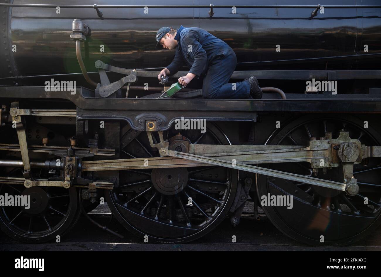 A volunteer oils the S15 class steam locomotive 506 as it is readied ...