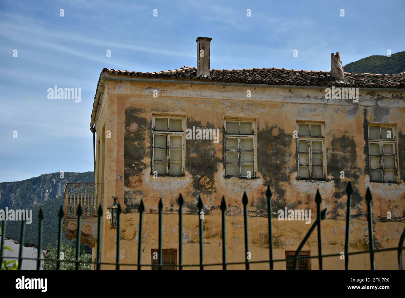 Old abandoned Neoclassical style house with weathered stucco walls and ...