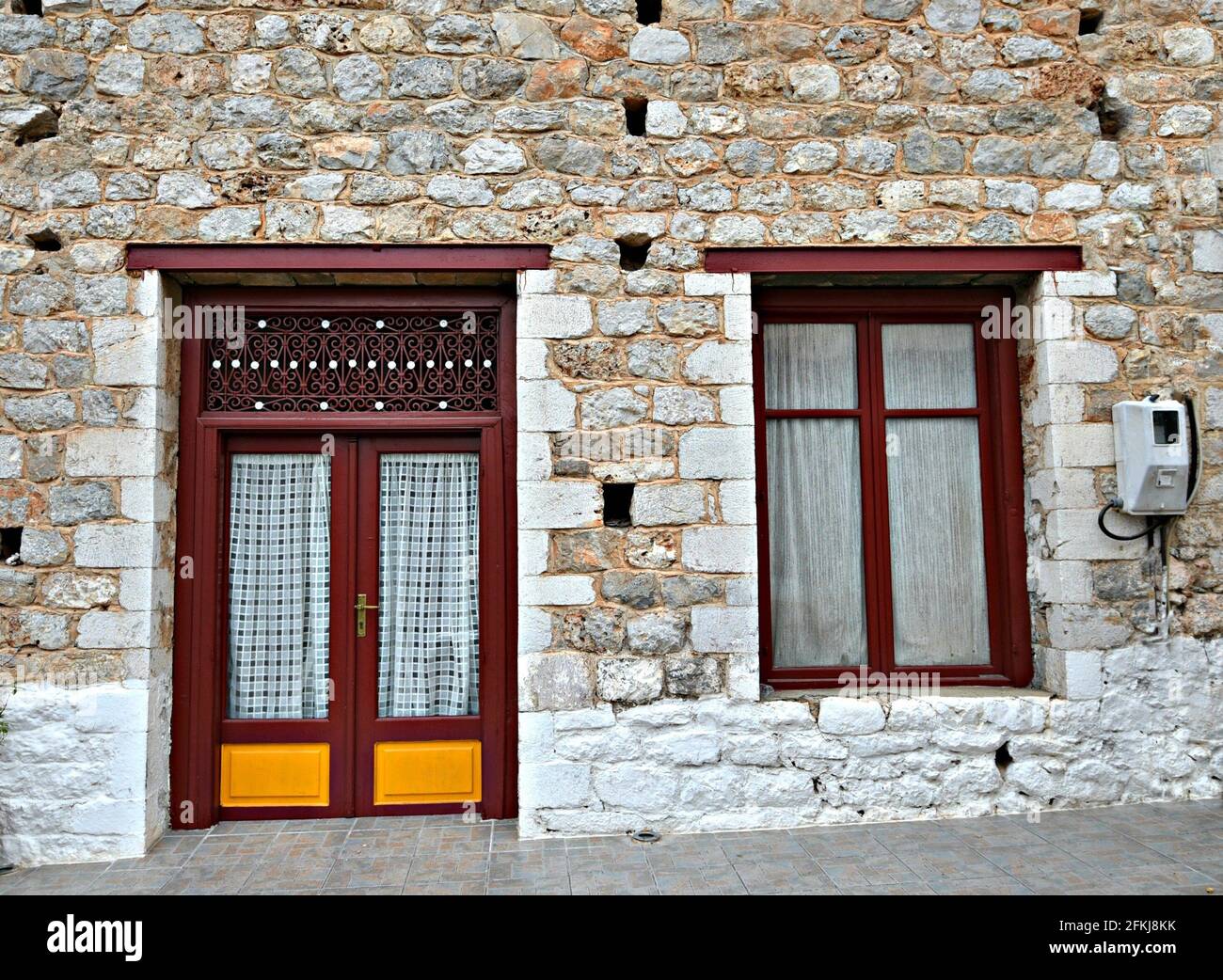 Traditional rural house facade with a handcrafted stone wall and a ...