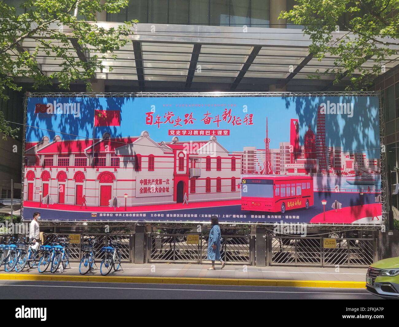 A woman walks past a giant banners celebrating the 100th birthday of ...