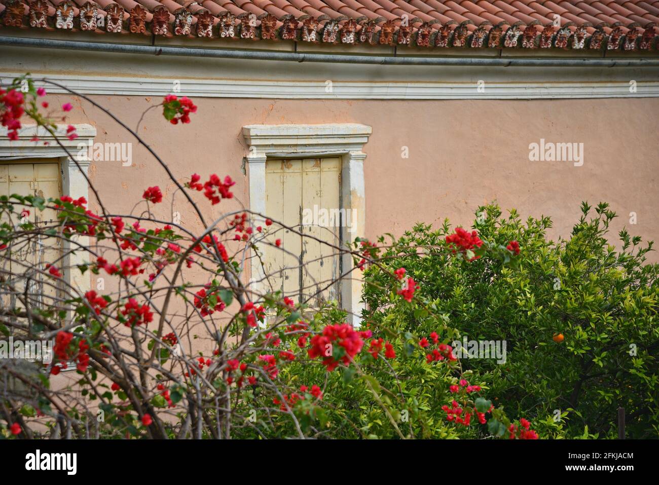Neoclassical house facade with a clay tile rooftop, a stucco wall and ...