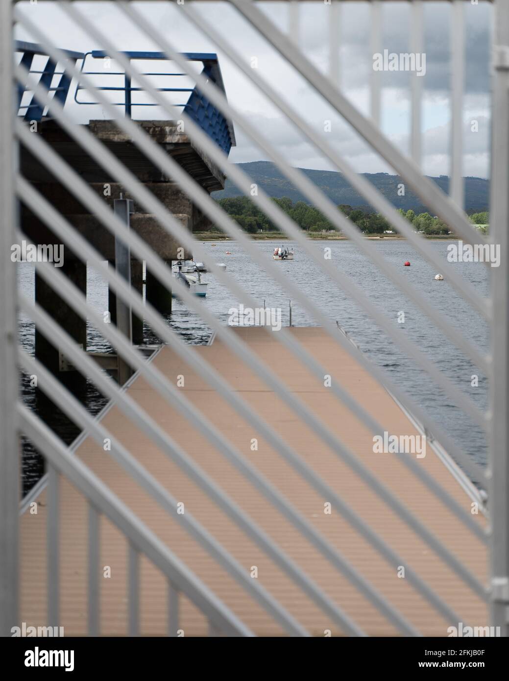 A selective focus of a dock behind a diagonal metal fence Stock Photo ...