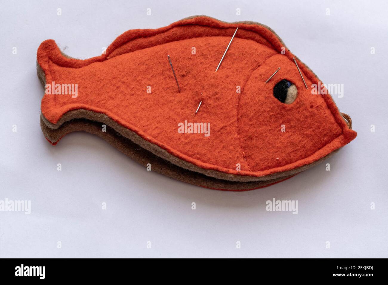 Old fashioned orange pin cushion in the shape of a flat fish with ...