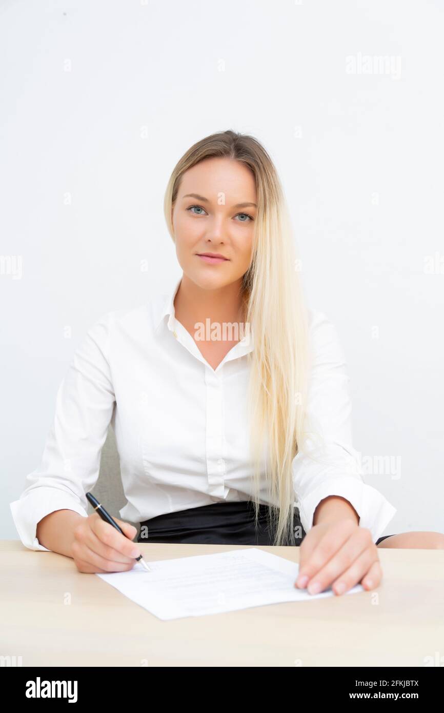 Portrait of beautiful business woman ready to sign a document looking ...