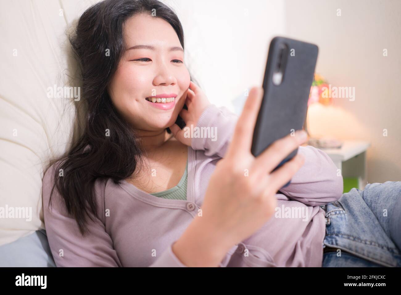 Asian girl with hand phone - home lifestyle portrait of young happy and ...