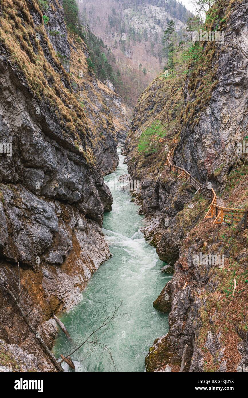 river flows through a gorge and a path for walkers is on the right side ...