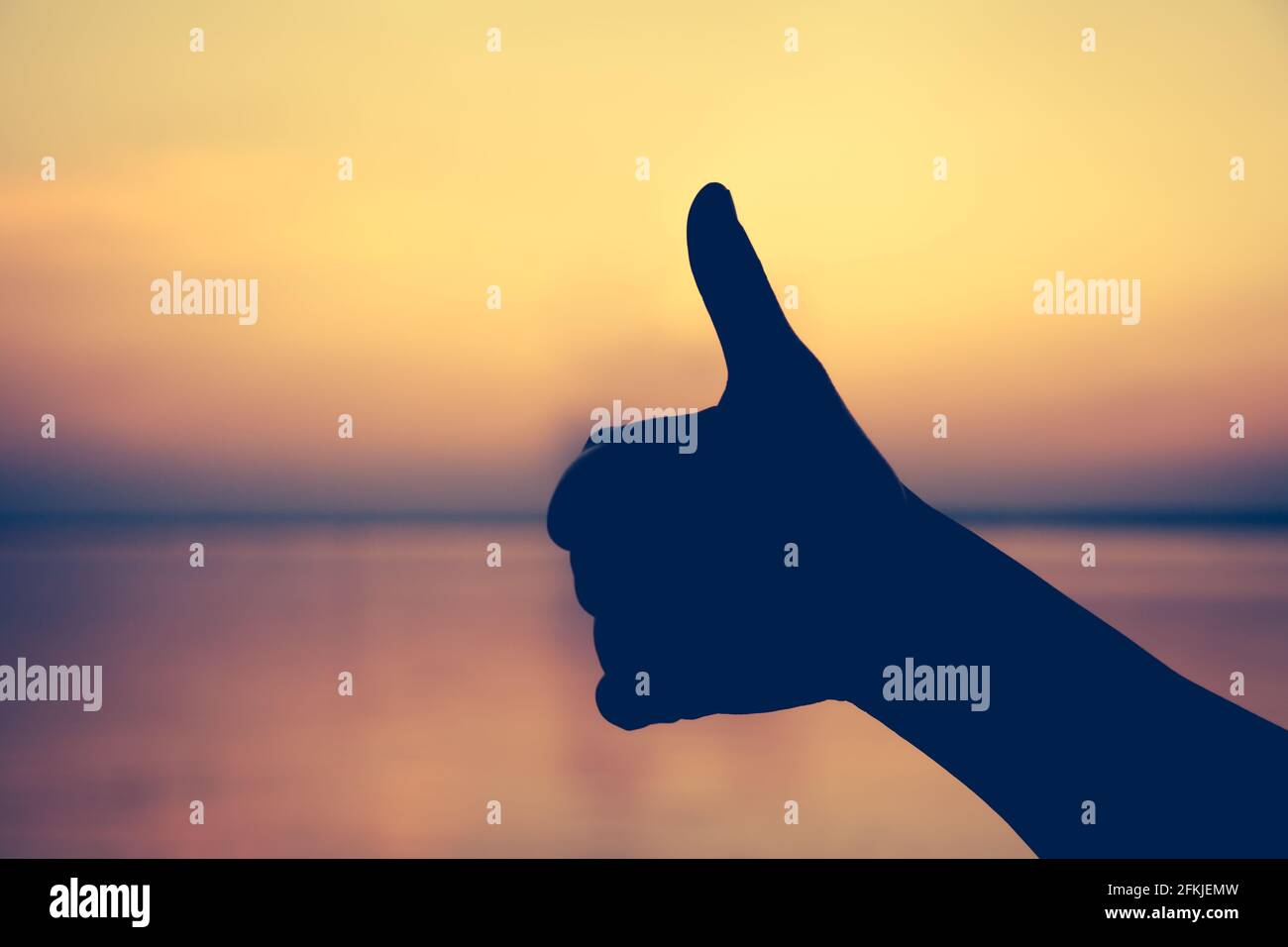 Hand thumb up on colorful sunset sky background. Gesture of the hand ...