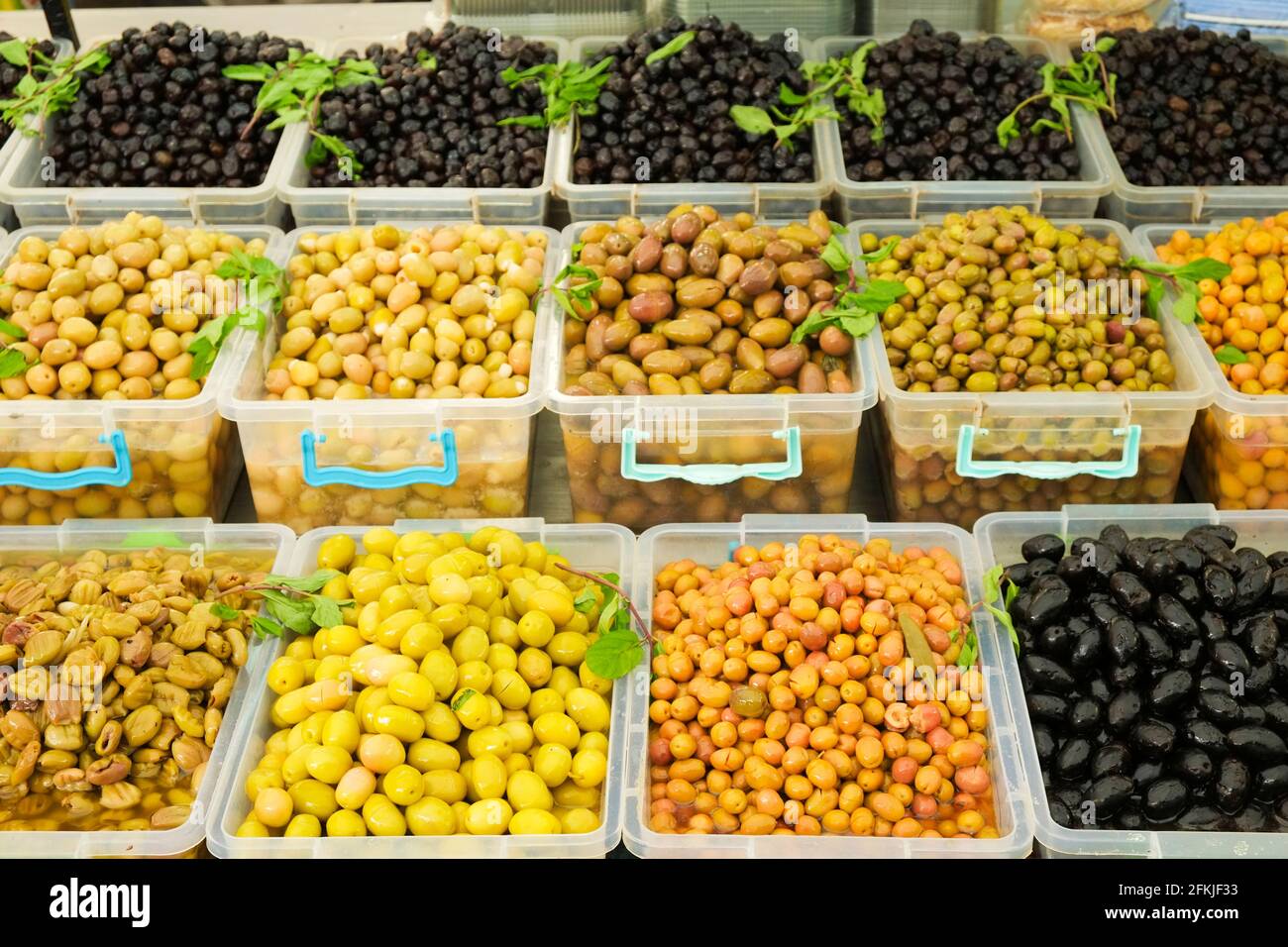 Multiple plastic containers with pile of ripe organic mixed greek ...