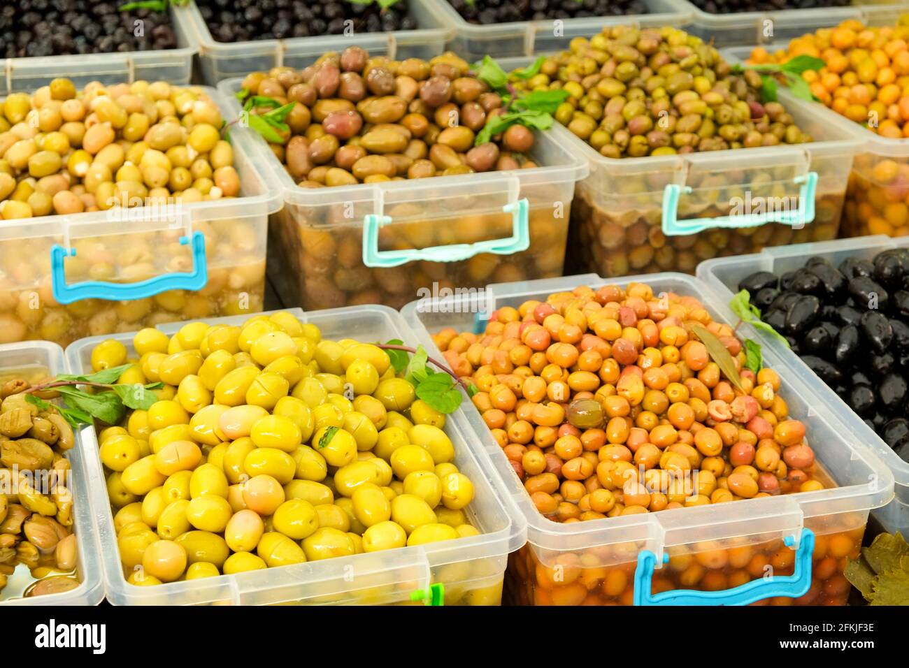 Multiple plastic containers with pile of ripe organic mixed greek ...