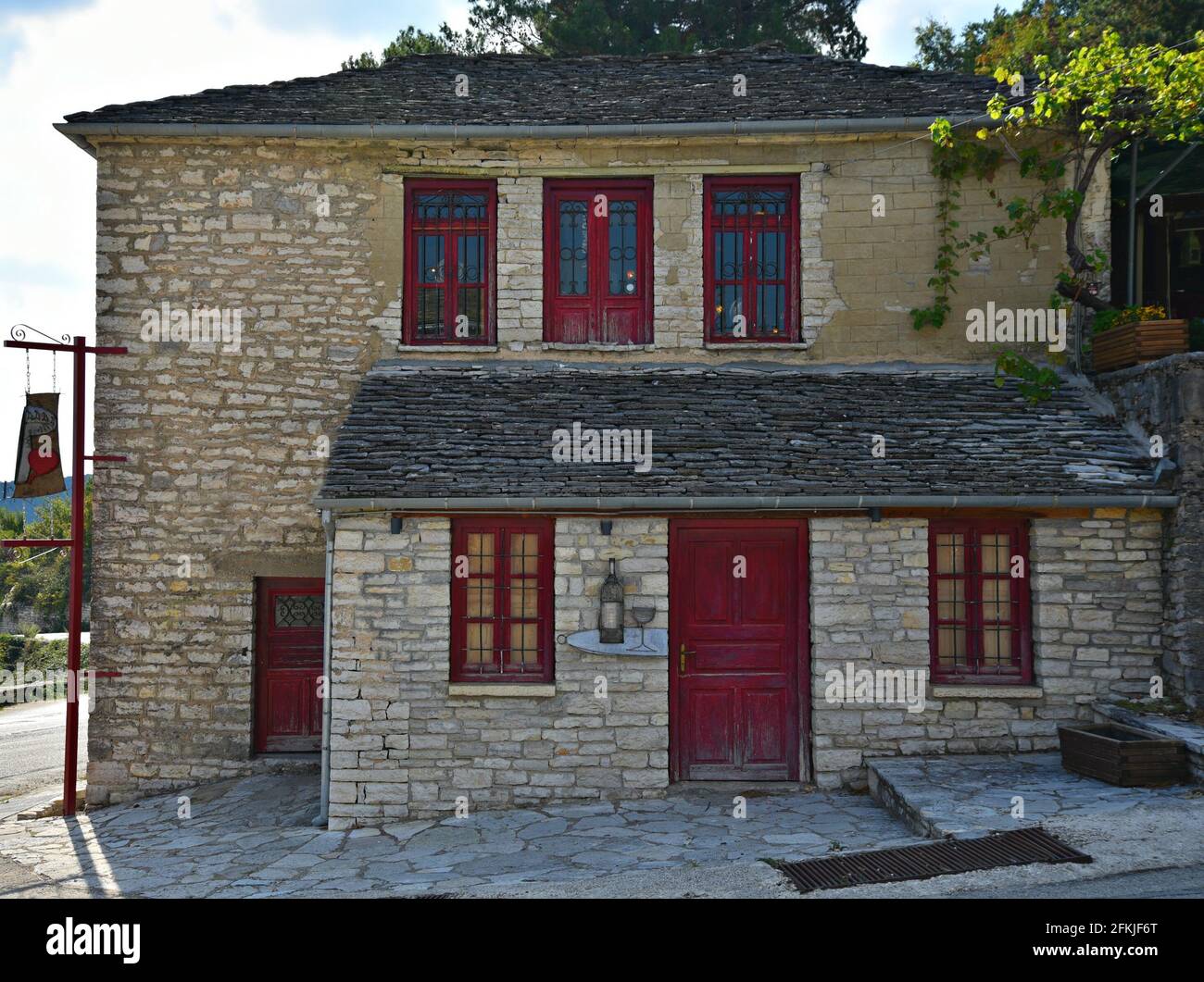 Traditional stone built Greek taverna with a slate rooftop and red ...