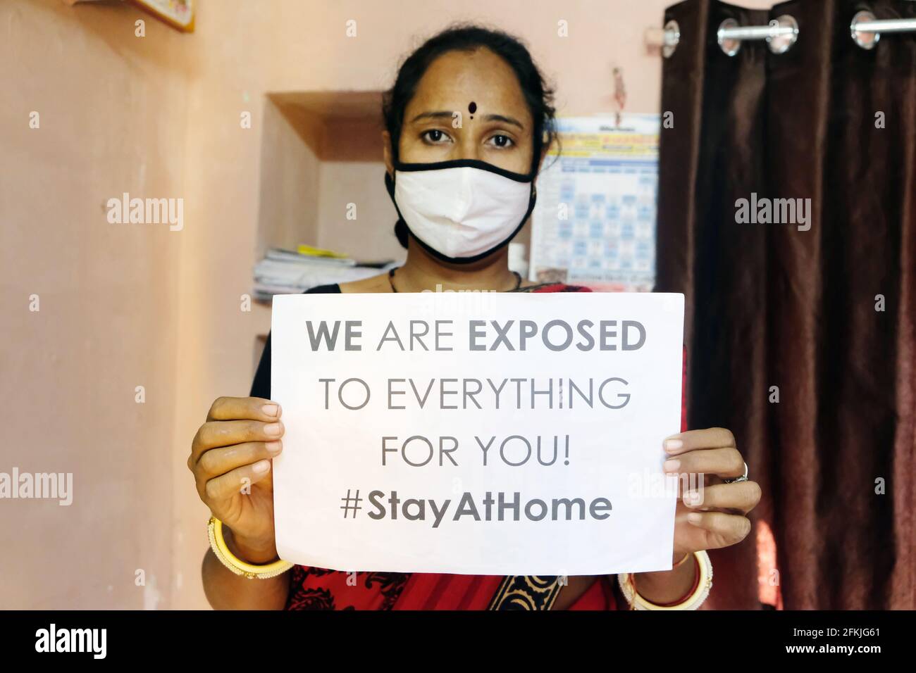 An Indian female holding a poster with the message "stay home" during ...