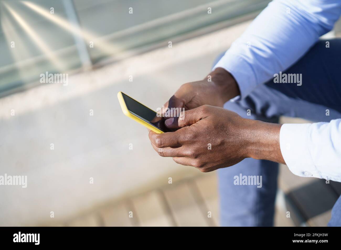 Hands of unrecognizable black man using a smartphone Stock Photo - Alamy