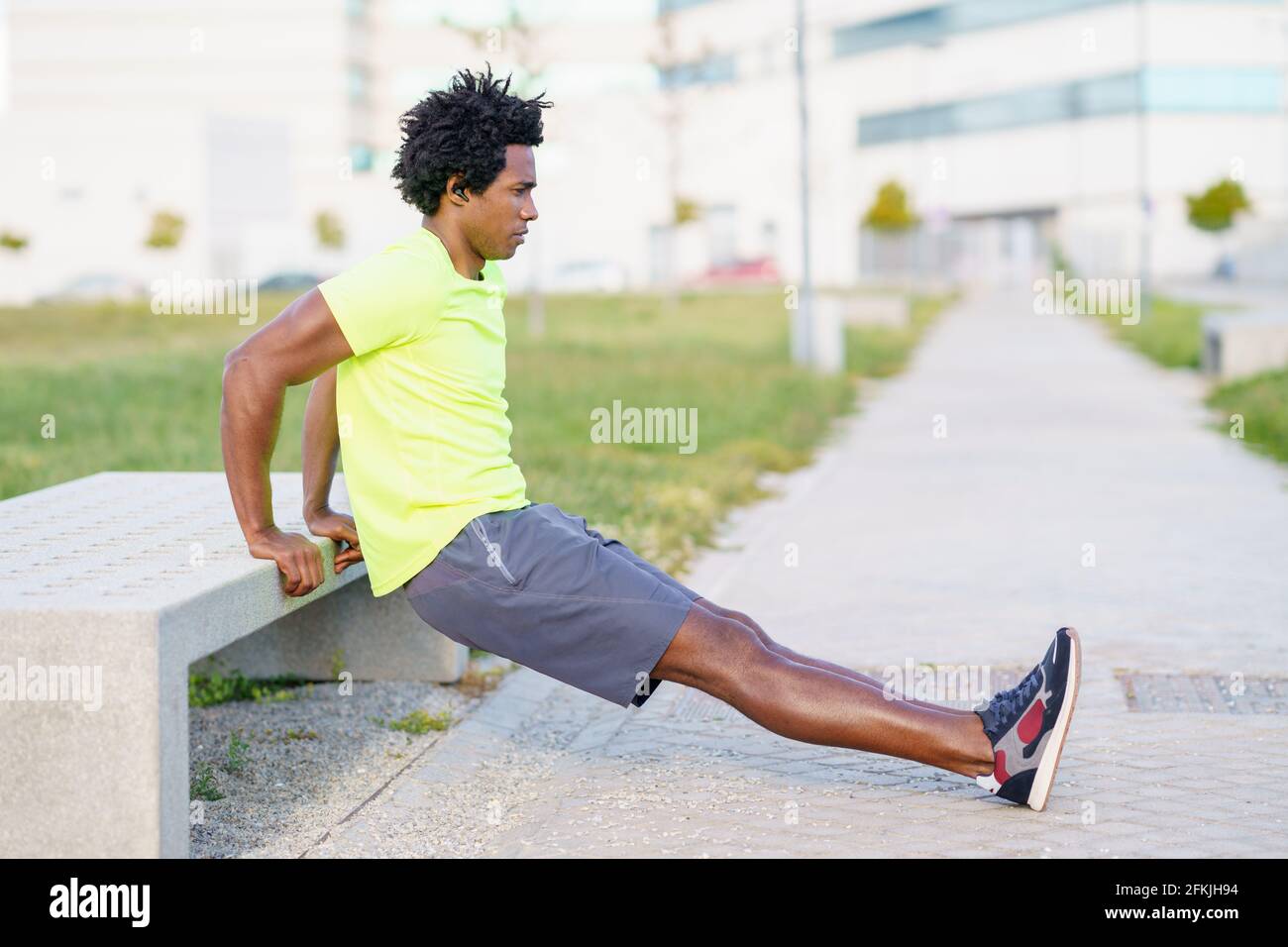 Black man doing triceps dip exercise on city street bench Stock Photo ...