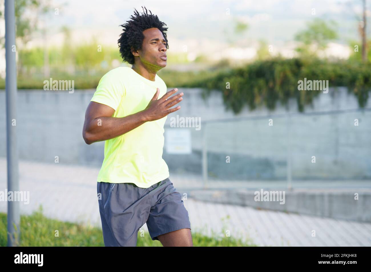 Black athletic man running in an urban park Stock Photo - Alamy