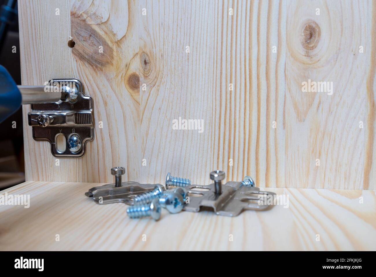 hands with screwdriver screwing hinge on a door Stock Photo - Alamy