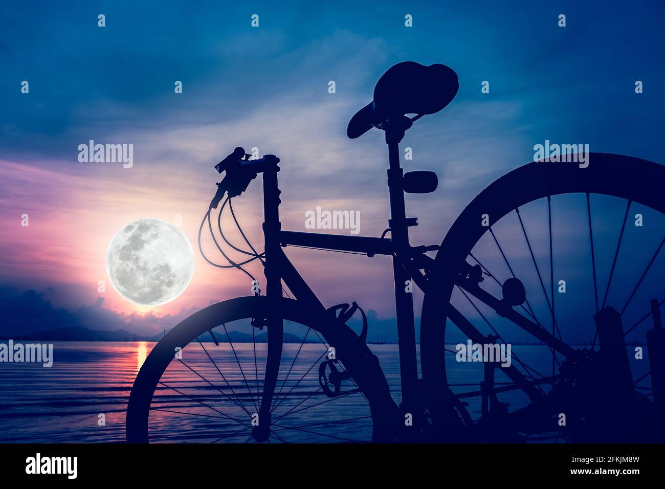 Silhouette of bicycle on the beach against beautiful full moon on ...