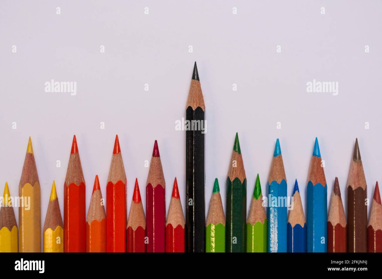 White background with a parallel arrangement of colored pencils With a ...